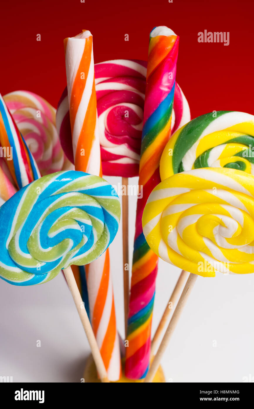 Multicolored sweet candy canes and twirls on wooden sticks, variety ...