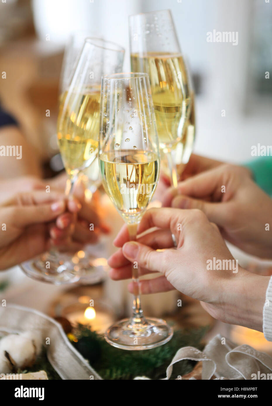 Group of friends toasting with champagne while having Christmas dinner ...