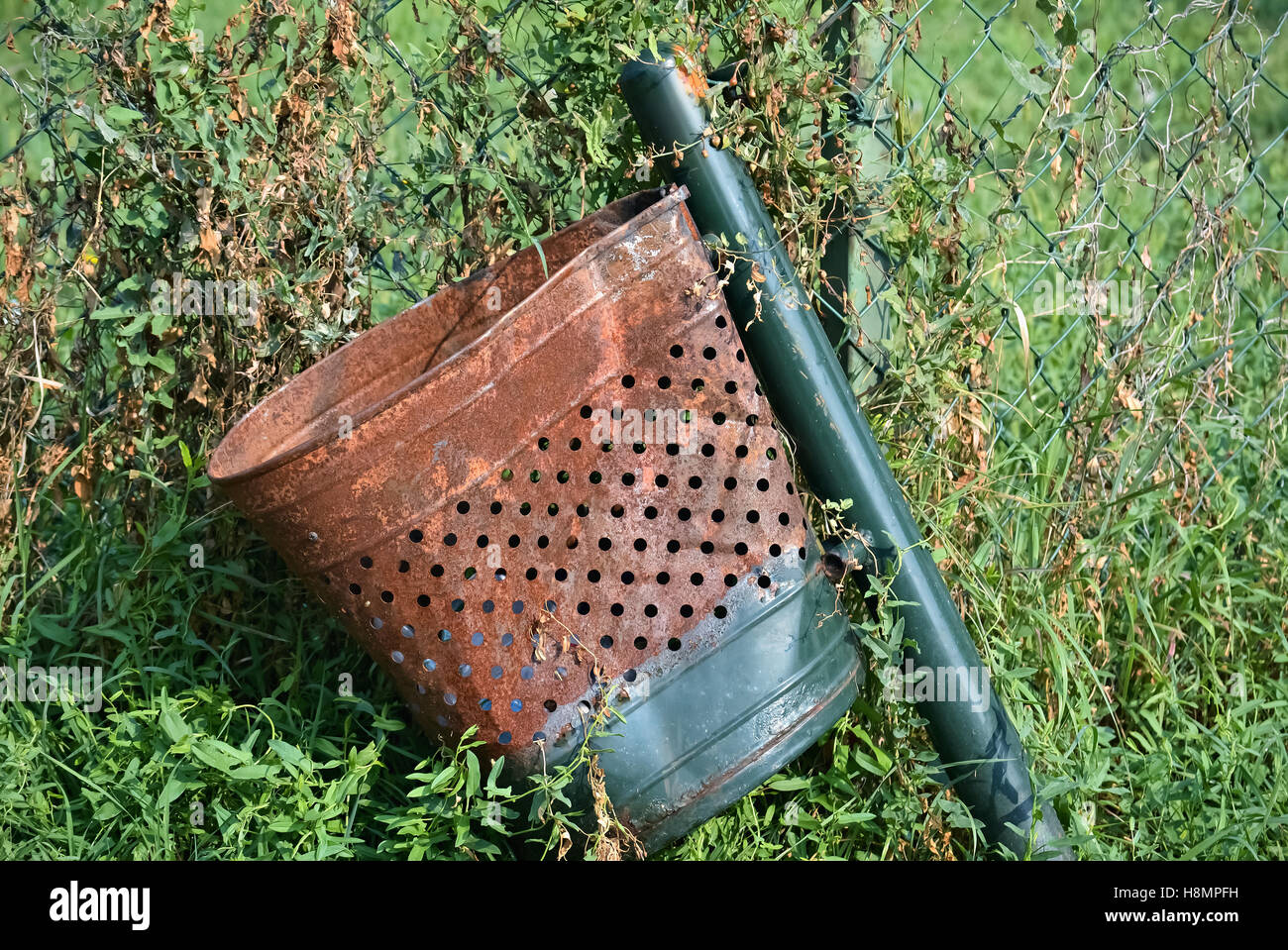 Closeup of a broken and rusty trash can in the park Stock Photo - Alamy