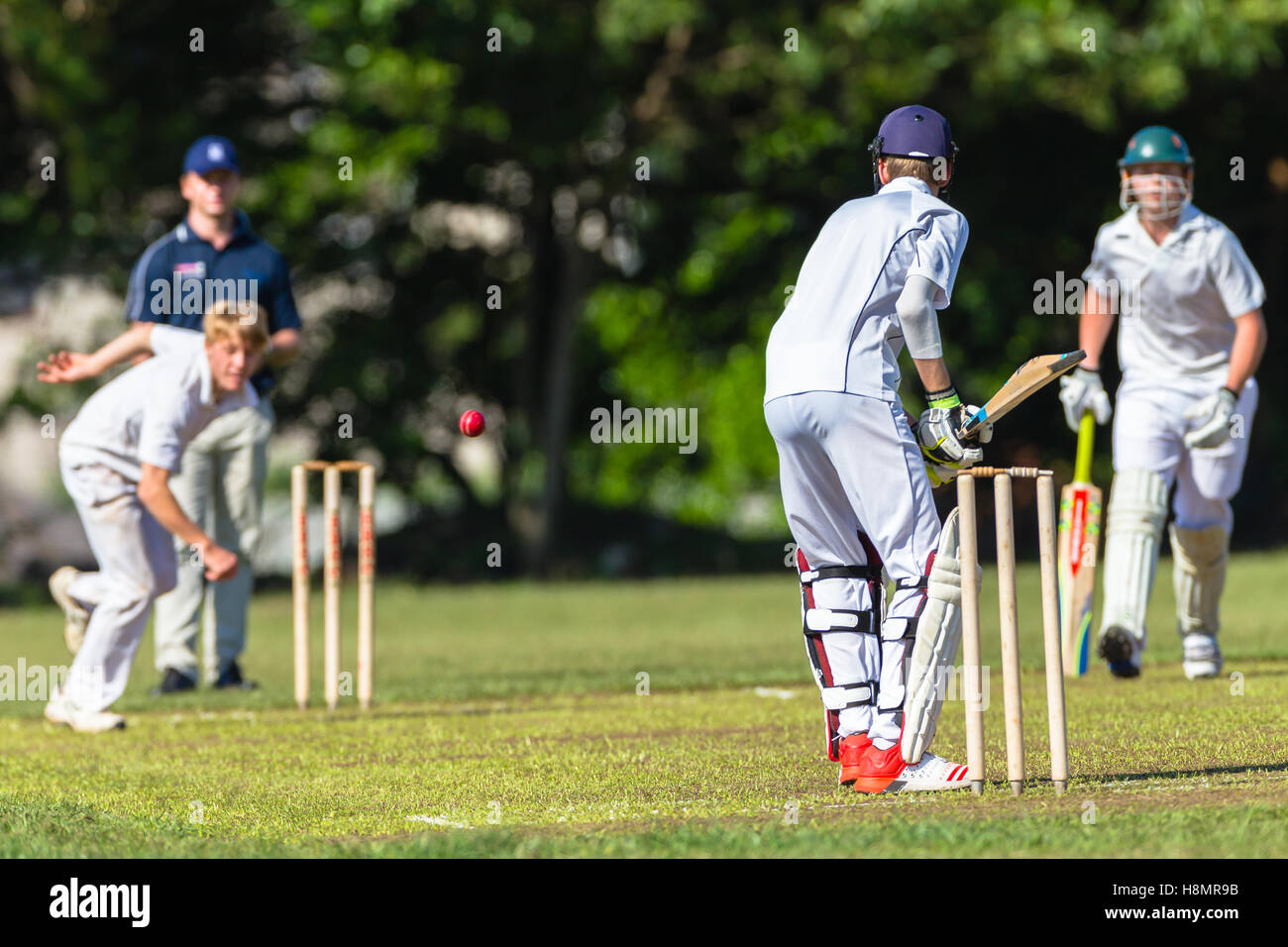 Cricket game teenagers high schools batsman bowler ball striking action ...