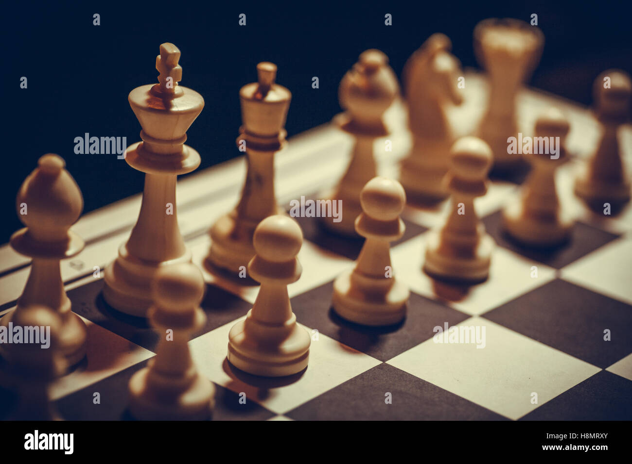 Shot of a chess board, with white pieces in focus, with shallow depth ...