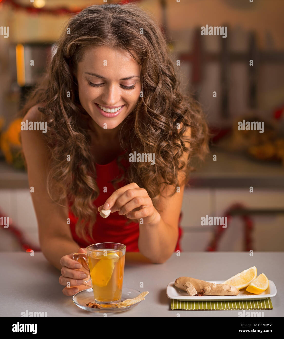 Happy young woman putting brown sugar cube into ginger tea Stock Photo ...