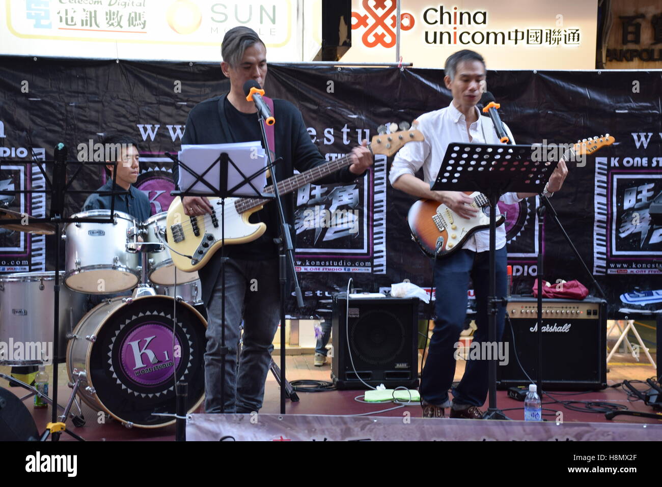 Hong Kong, China - Asian music trio performing on stage in the street ...