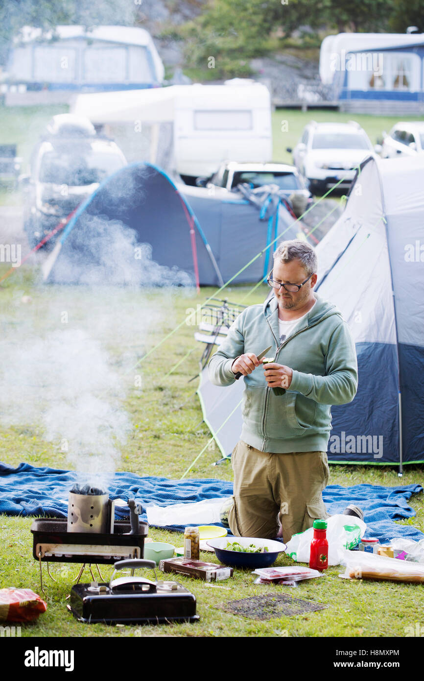 Mature man cooking at campsite Stock Photo - Alamy
