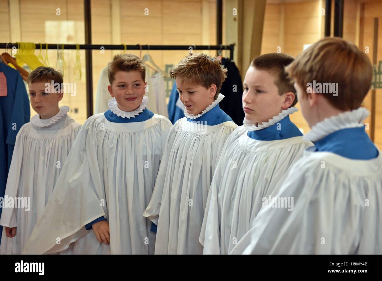 Five surpliced boy choristers at cassock fitting before first evensong ...