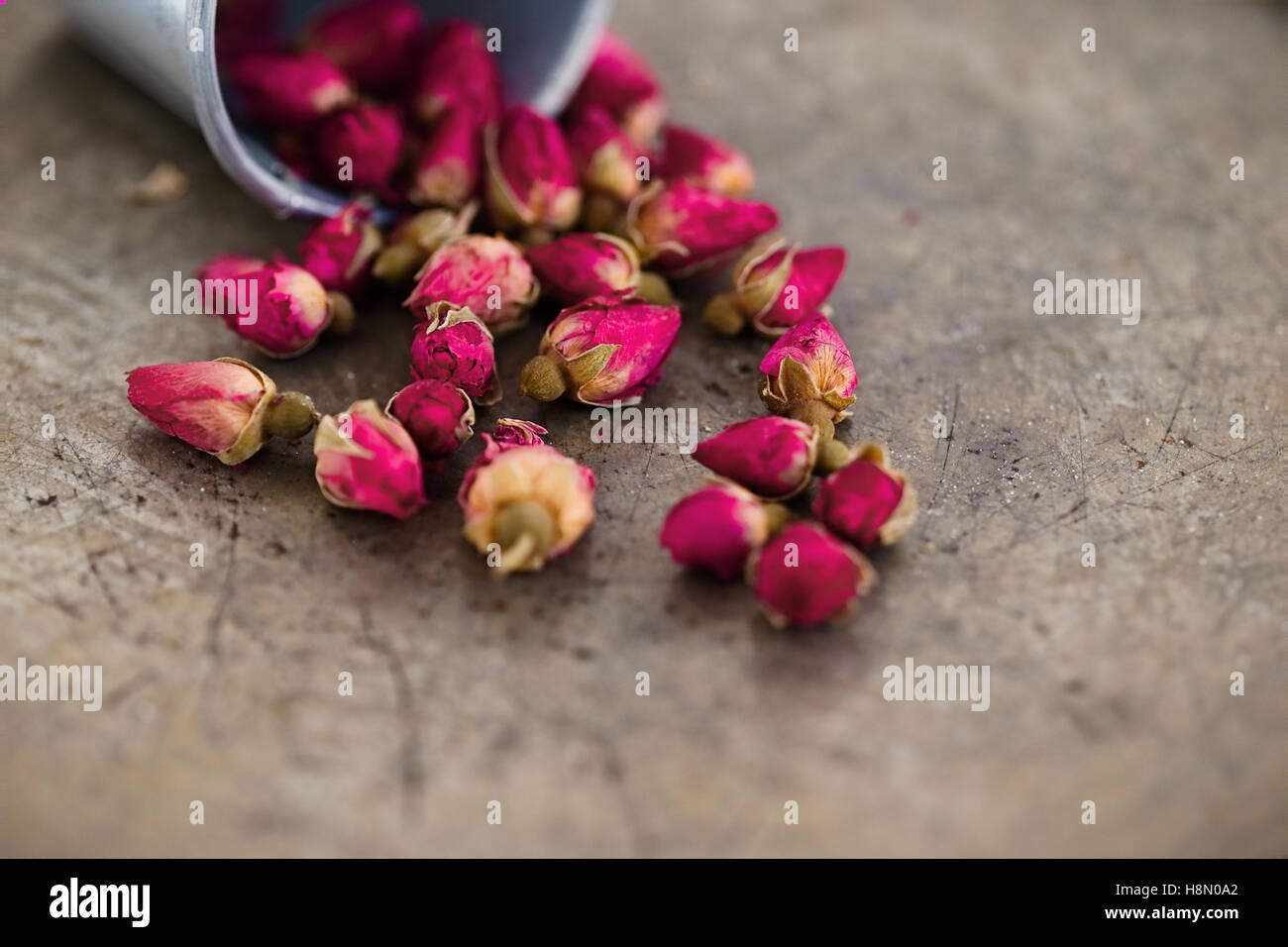 Small dried pink rose buds on a dark background Stock Photo - Alamy