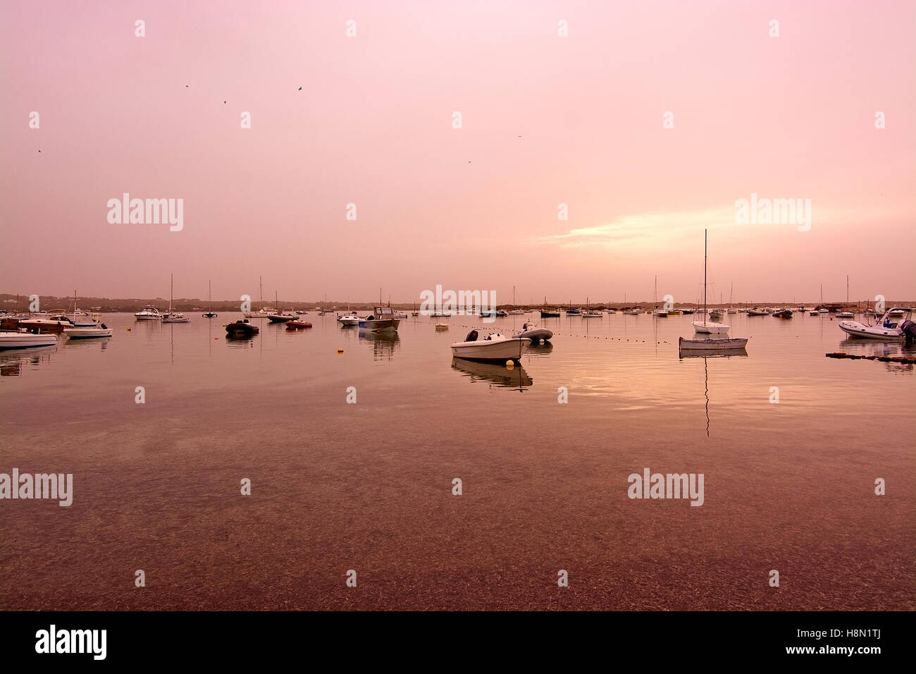 Formentera winter sunset seascape with moored boats on an overcast day ...