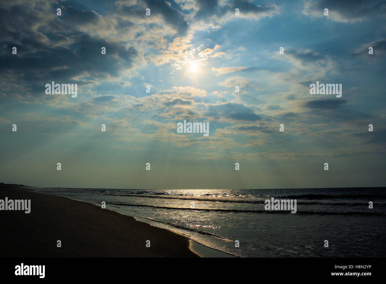 Sunset on ocean with waves breaking Stock Photo - Alamy