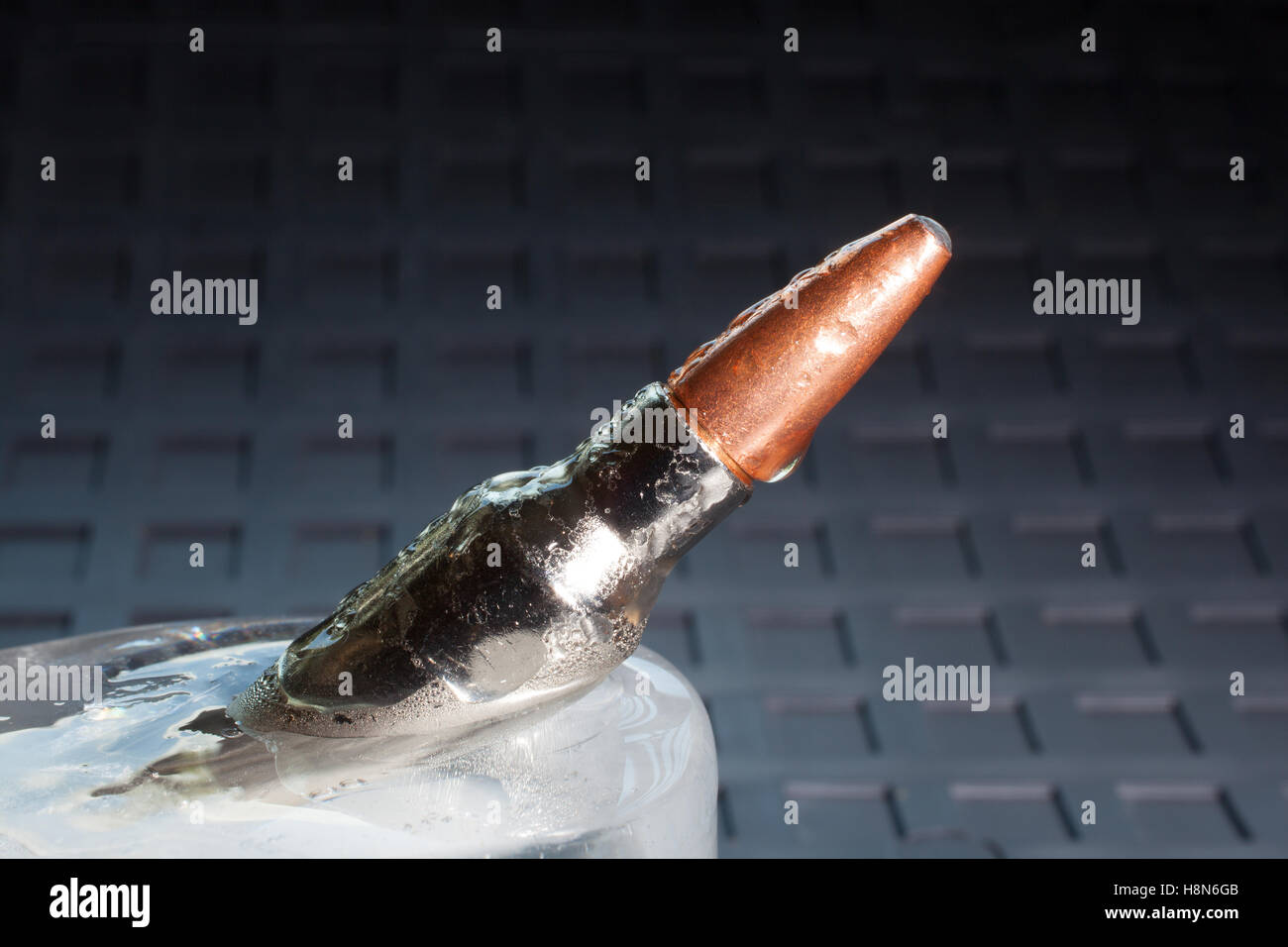 Copper tipped bullet that is in a block of ice Stock Photo - Alamy