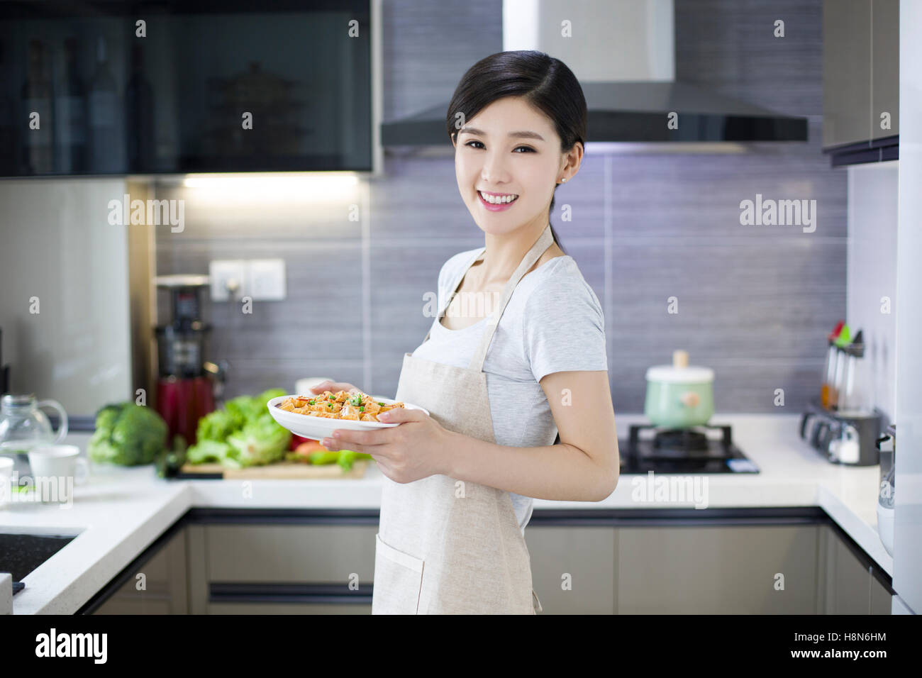 Happy young Chinese woman serving food Stock Photo - Alamy