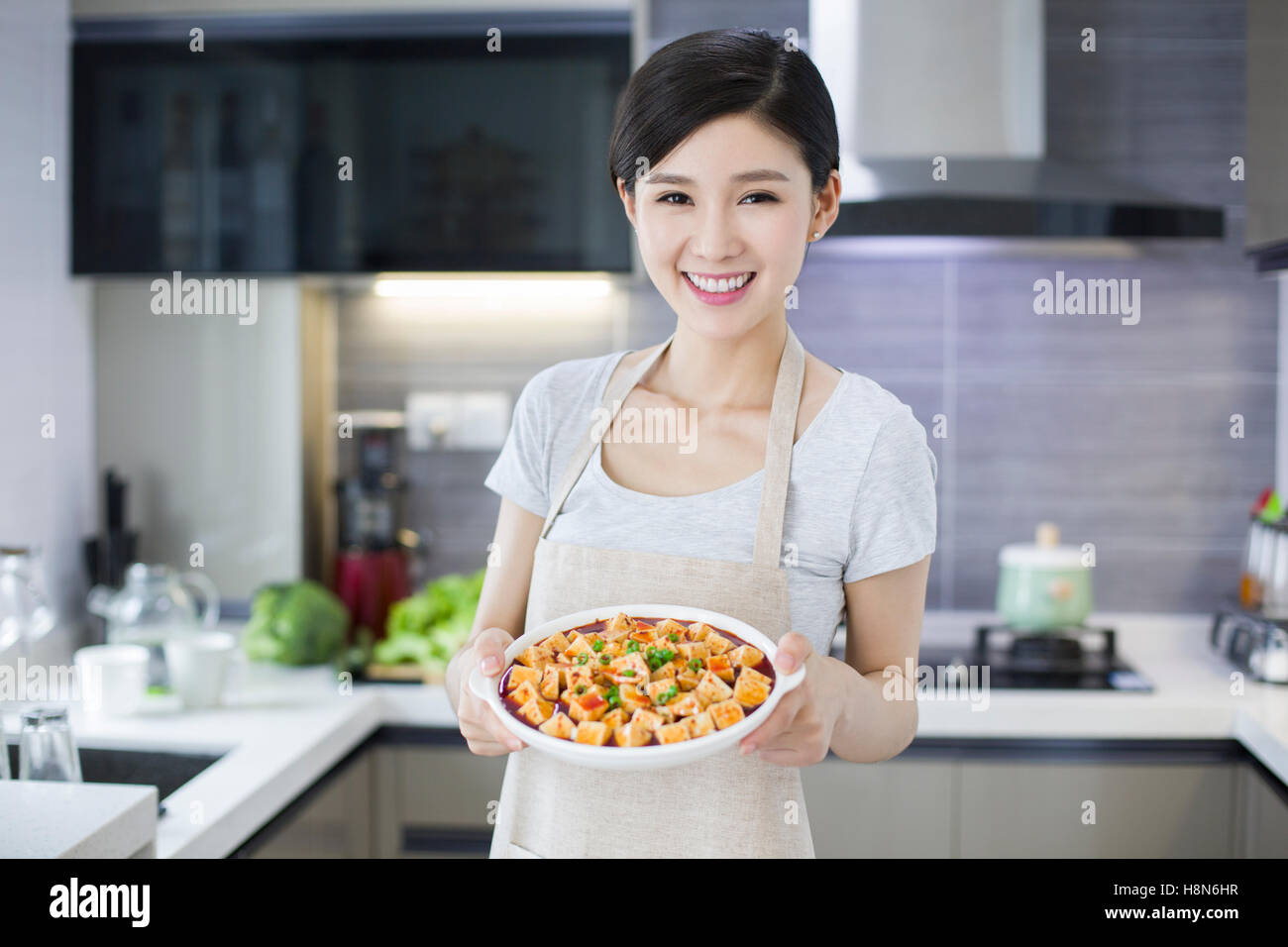 Happy young Chinese woman serving food Stock Photo - Alamy