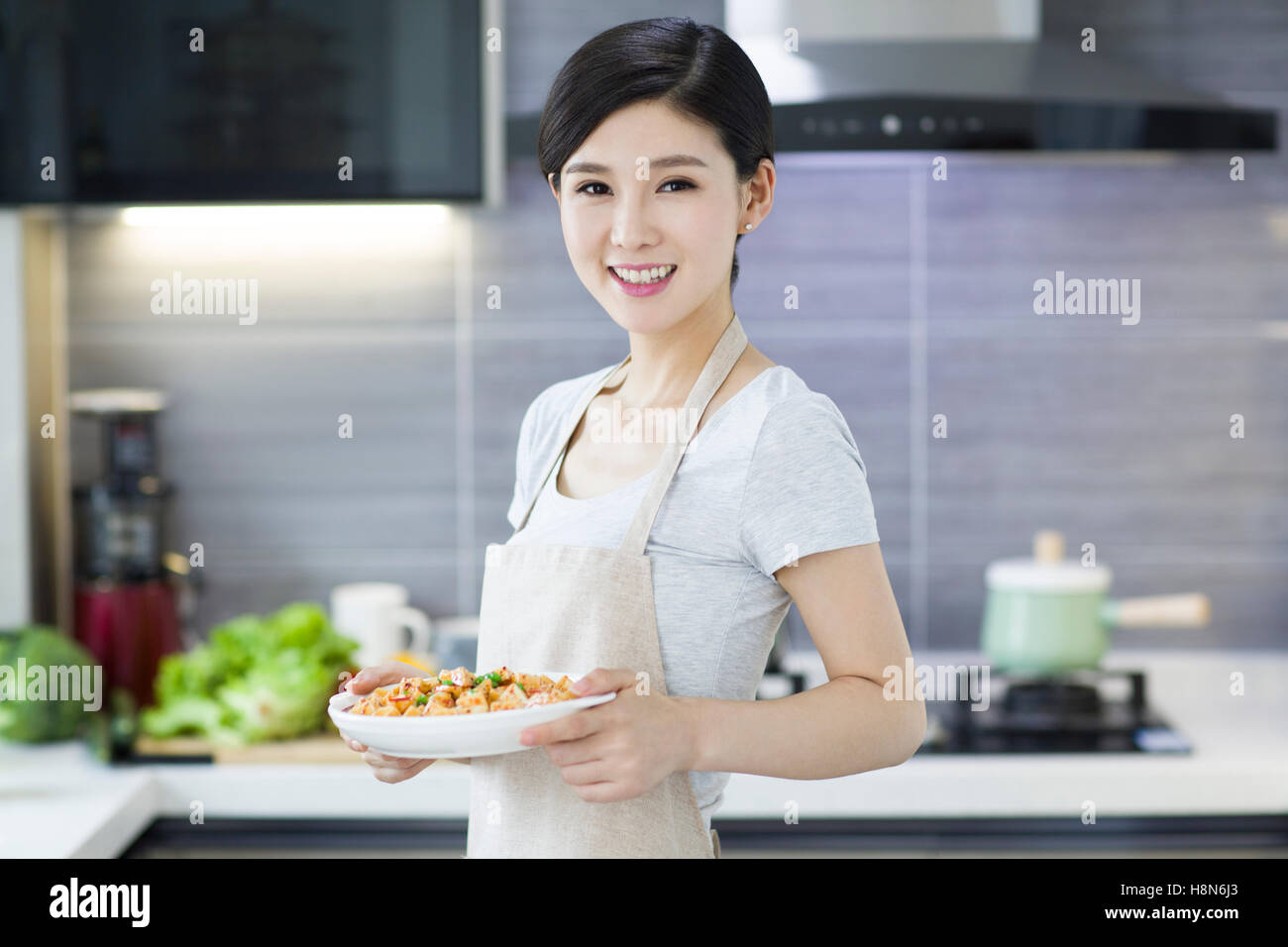 Happy young Chinese woman serving food Stock Photo - Alamy