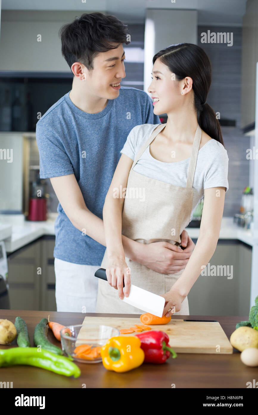 Happy young Chinese couple cooking in kitchen Stock Photo - Alamy