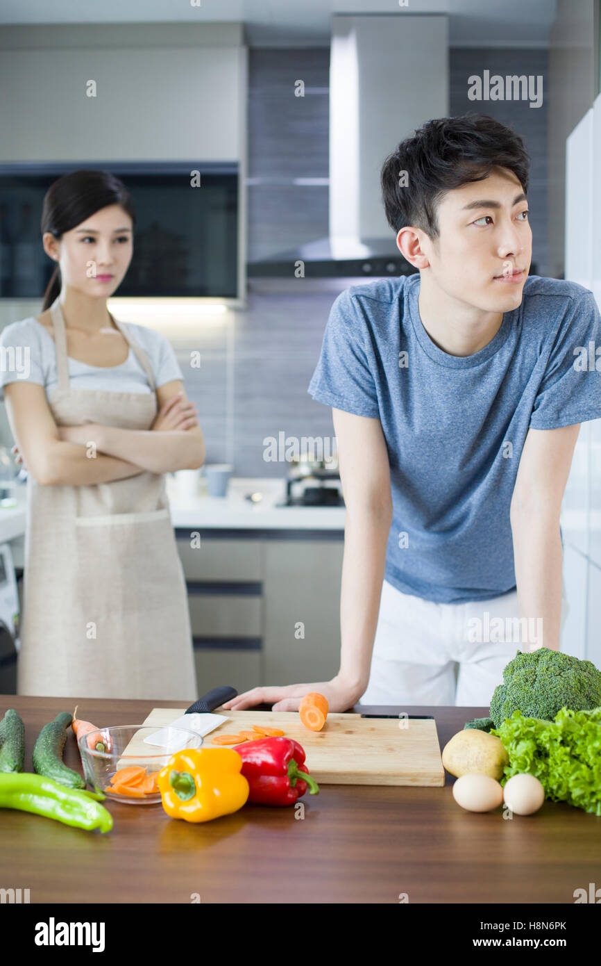 Young Chinese couple ignoring each other in kitchen Stock Photo - Alamy