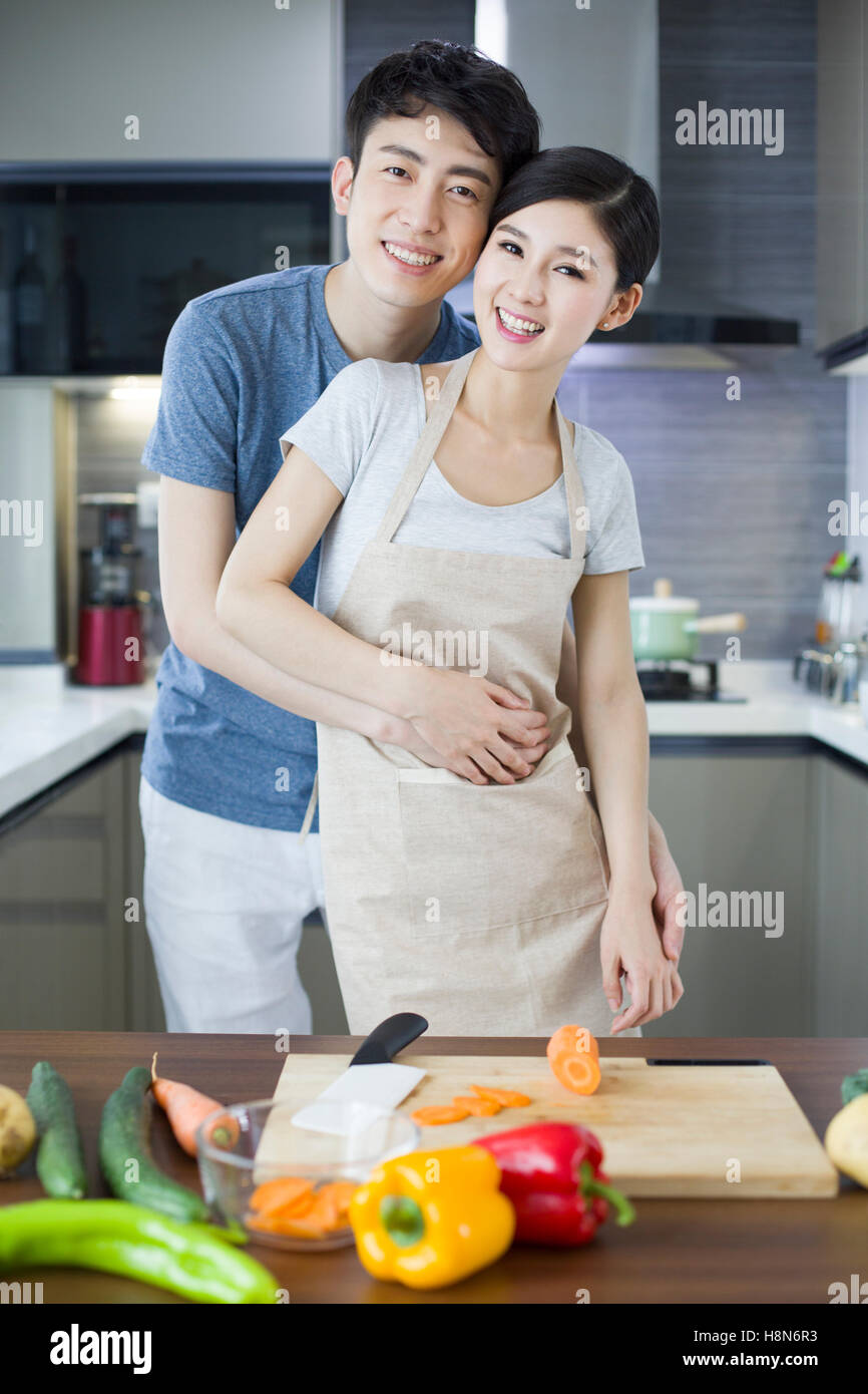 Happy young Chinese couple cooking in kitchen Stock Photo - Alamy