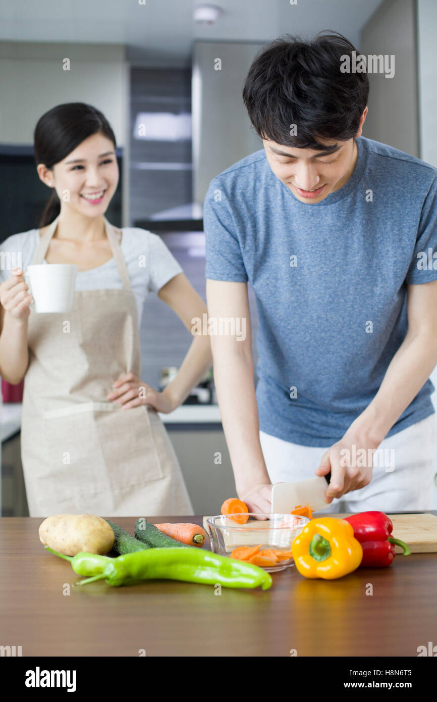 Happy young Chinese couple cooking in kitchen Stock Photo - Alamy