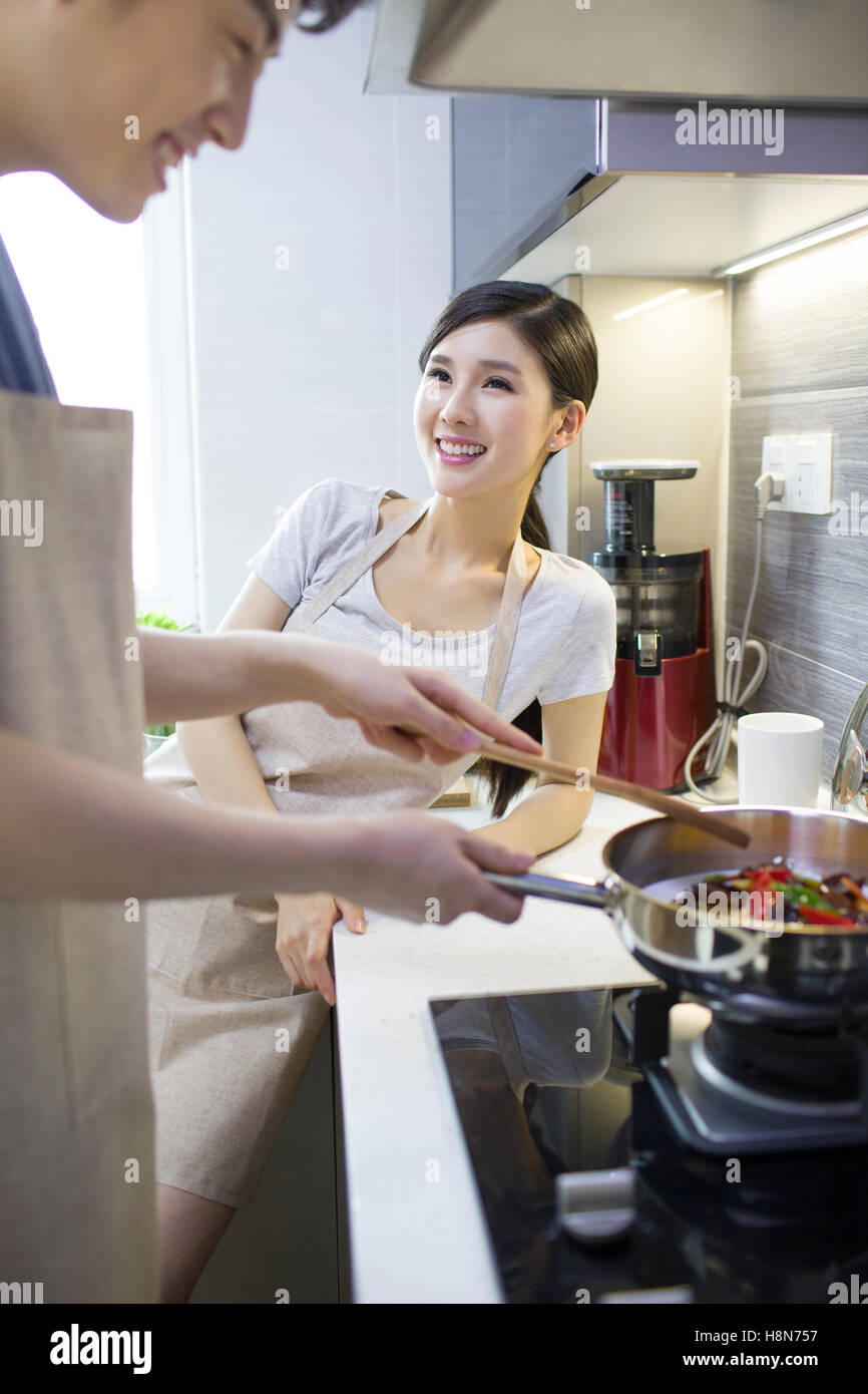 Happy young Chinese couple cooking in kitchen Stock Photo - Alamy