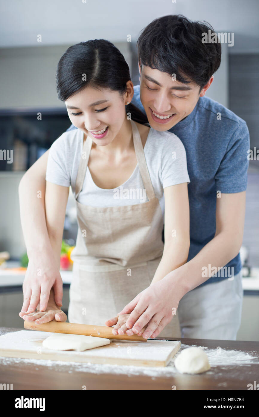 Happy young Chinese couple cooking in kitchen Stock Photo - Alamy
