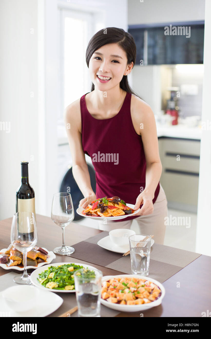 Happy young Chinese woman setting the table Stock Photo - Alamy