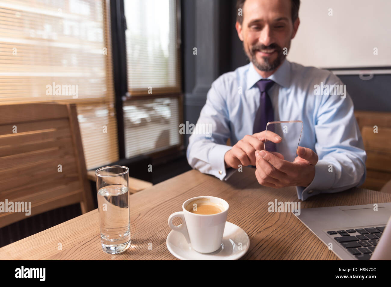 Happy positive man using an electronic device Stock Photo - Alamy