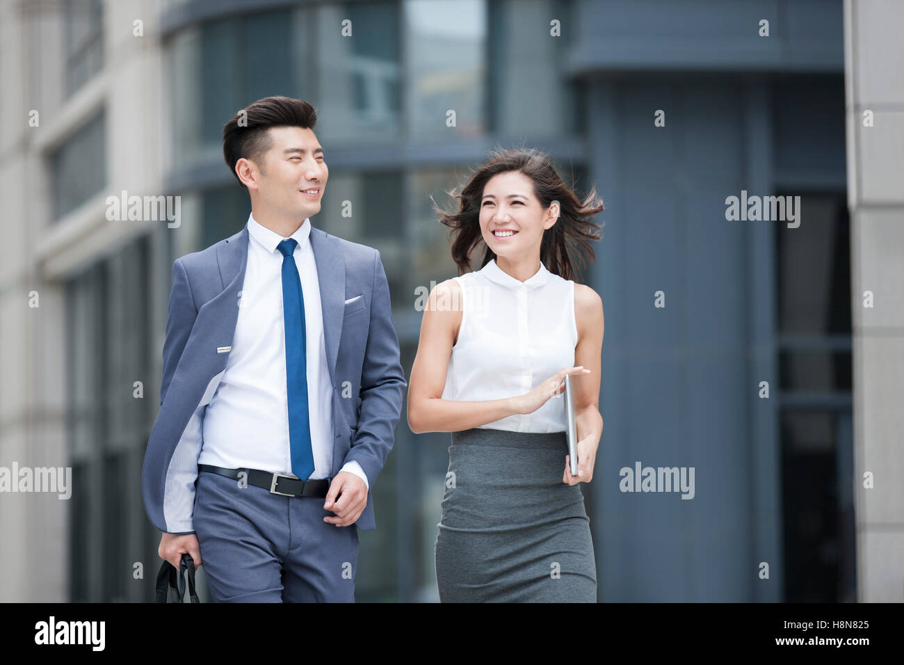 Confident Chinese business people talking and walking outdoors Stock ...