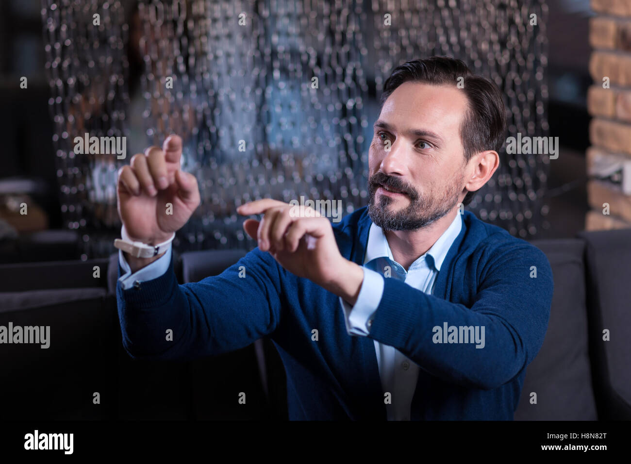 Curious handsome man using virtual sensory panel Stock Photo - Alamy