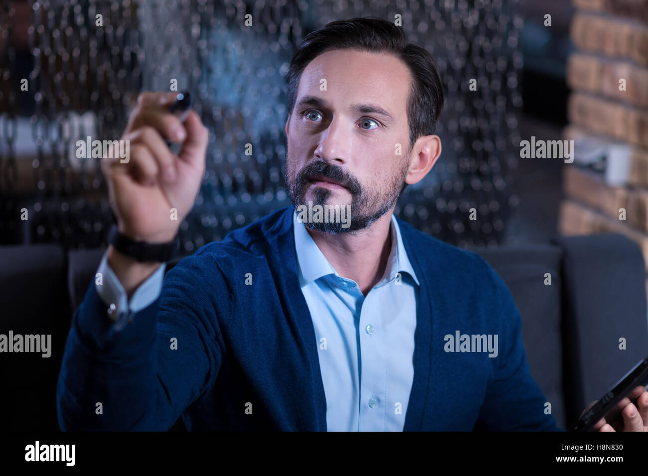 Serious nice man writing something in the virtual screen Stock Photo ...