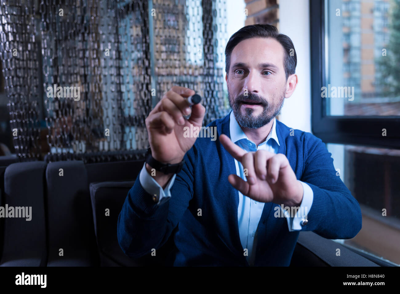 Positive cheerful man looking at the virtual sensory panel Stock Photo ...