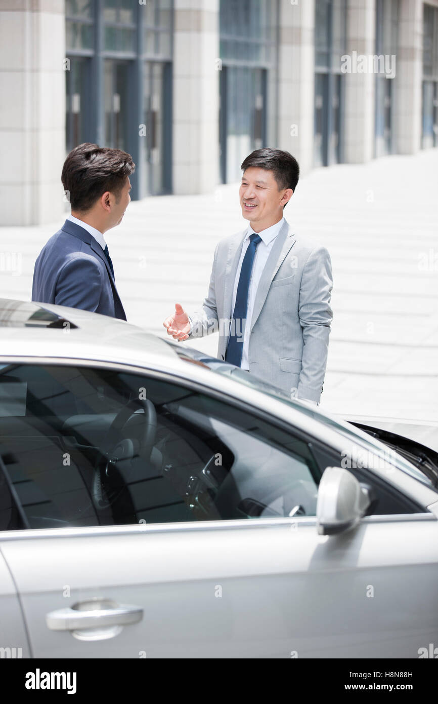 Confident Chinese businessmen talking outdoors Stock Photo - Alamy