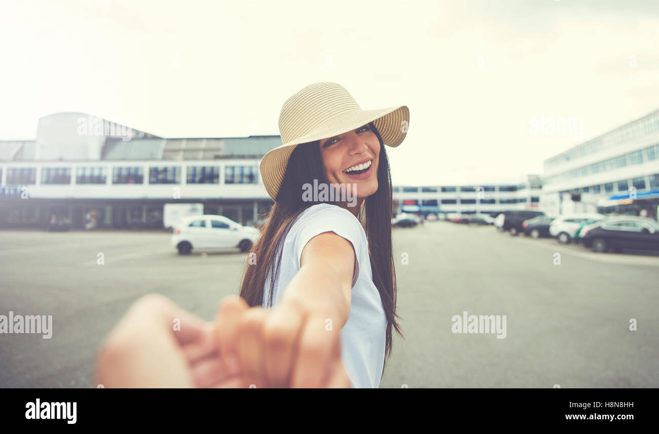 Woman with hand stretched towards camera smiles while turning away near ...