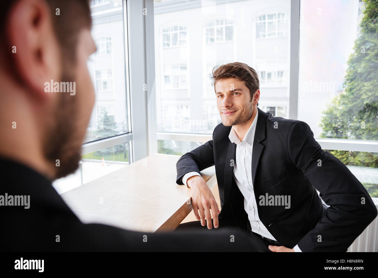 Two successful businessman sitting table hi-res stock photography and ...