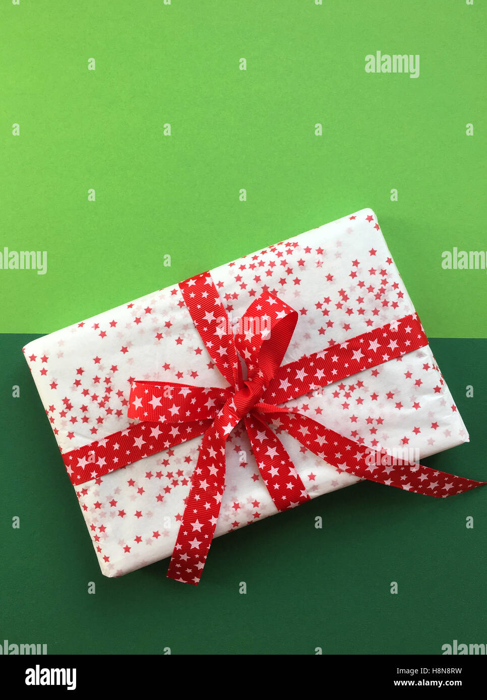 Present, beautifully wrapped and decorated with a red ribbon Stock ...