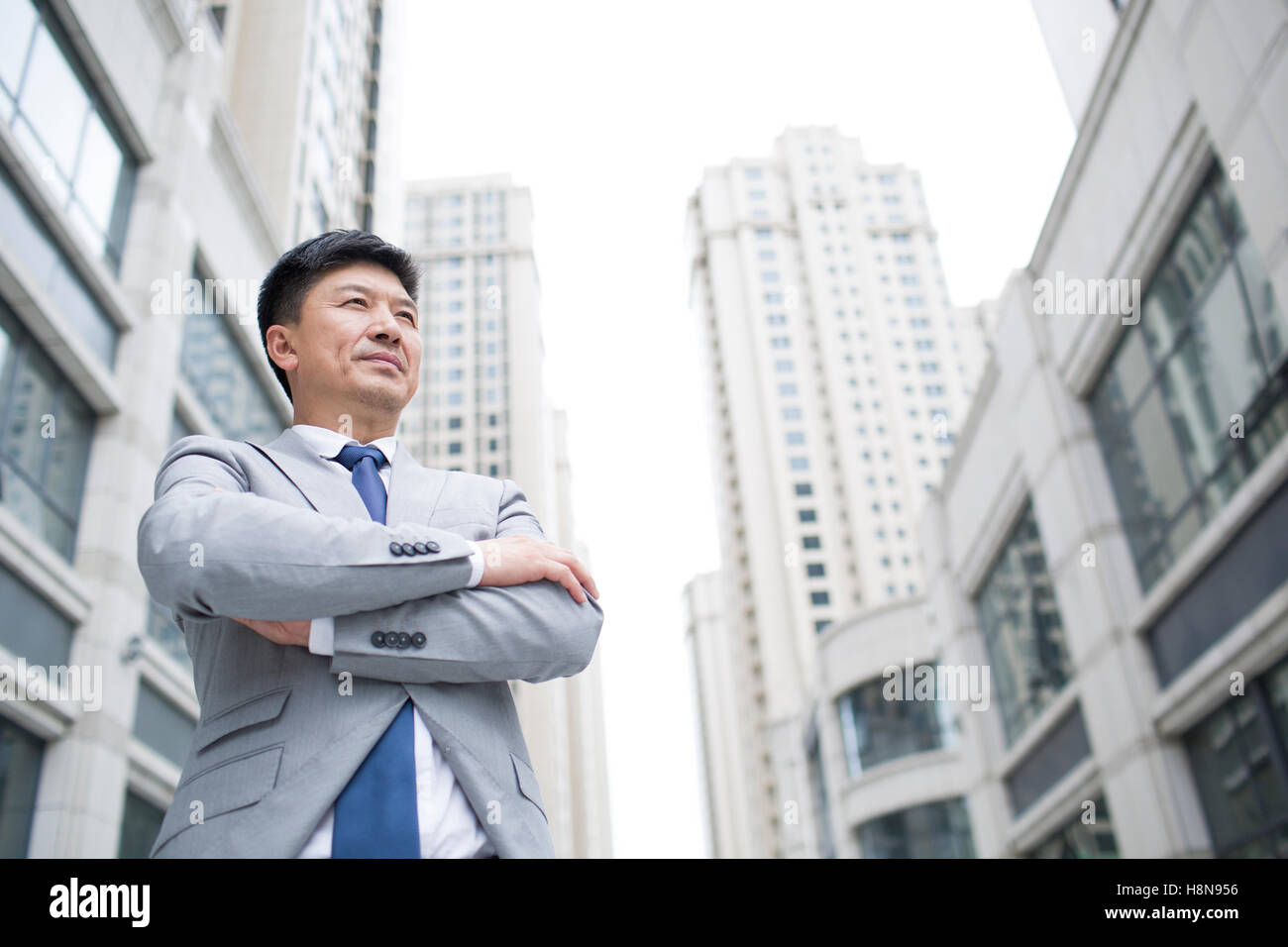 Businessman standing in front skyscraper hi-res stock photography and ...