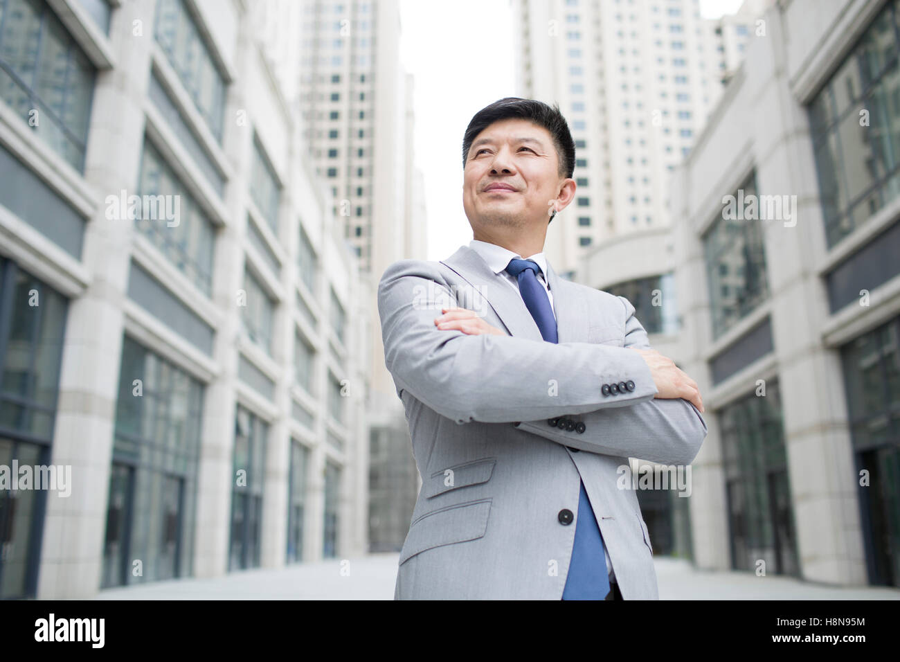 Confident Chinese businessman in front of skyscraper Stock Photo - Alamy