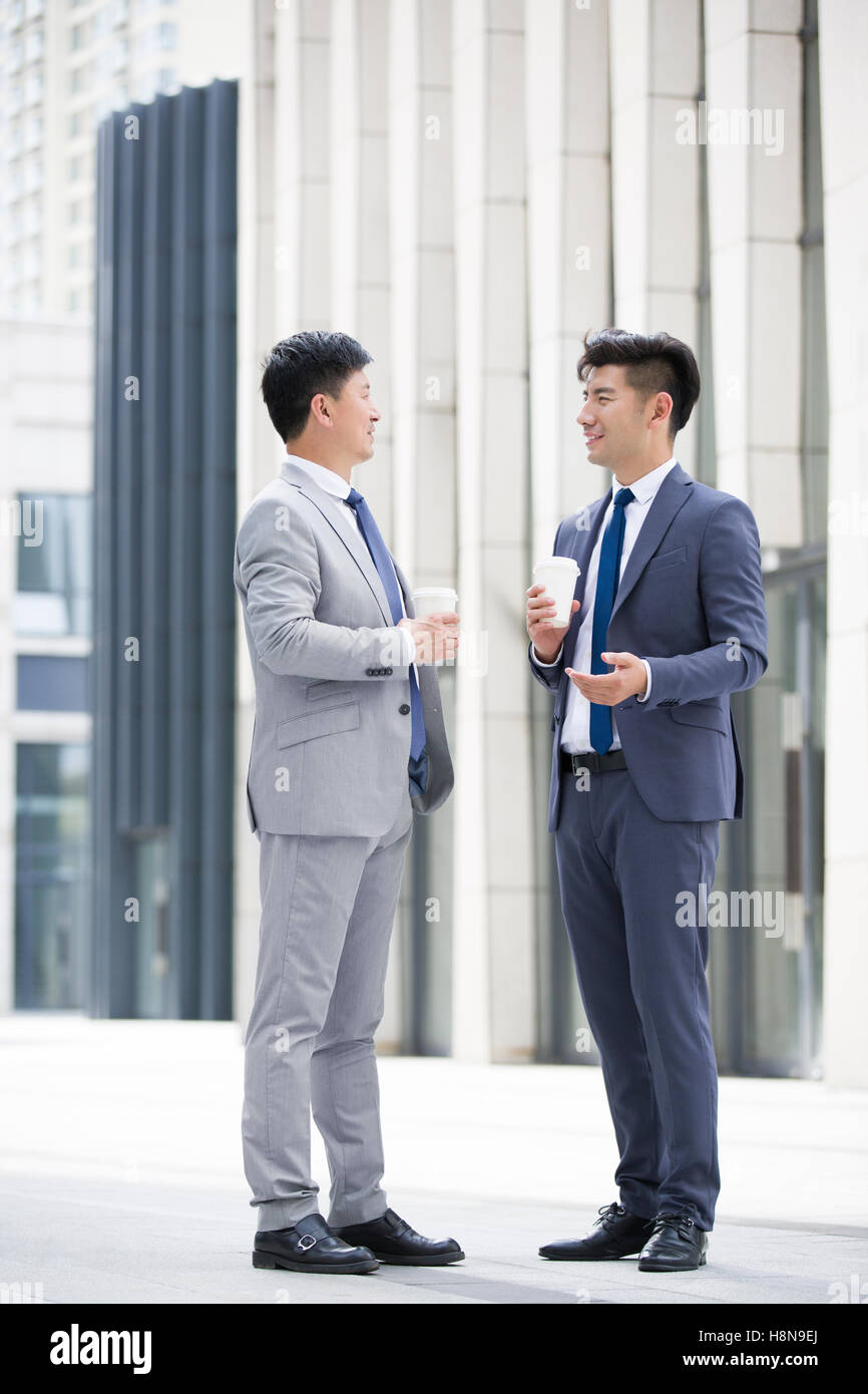 Confident Chinese businessmen talking outdoors Stock Photo - Alamy