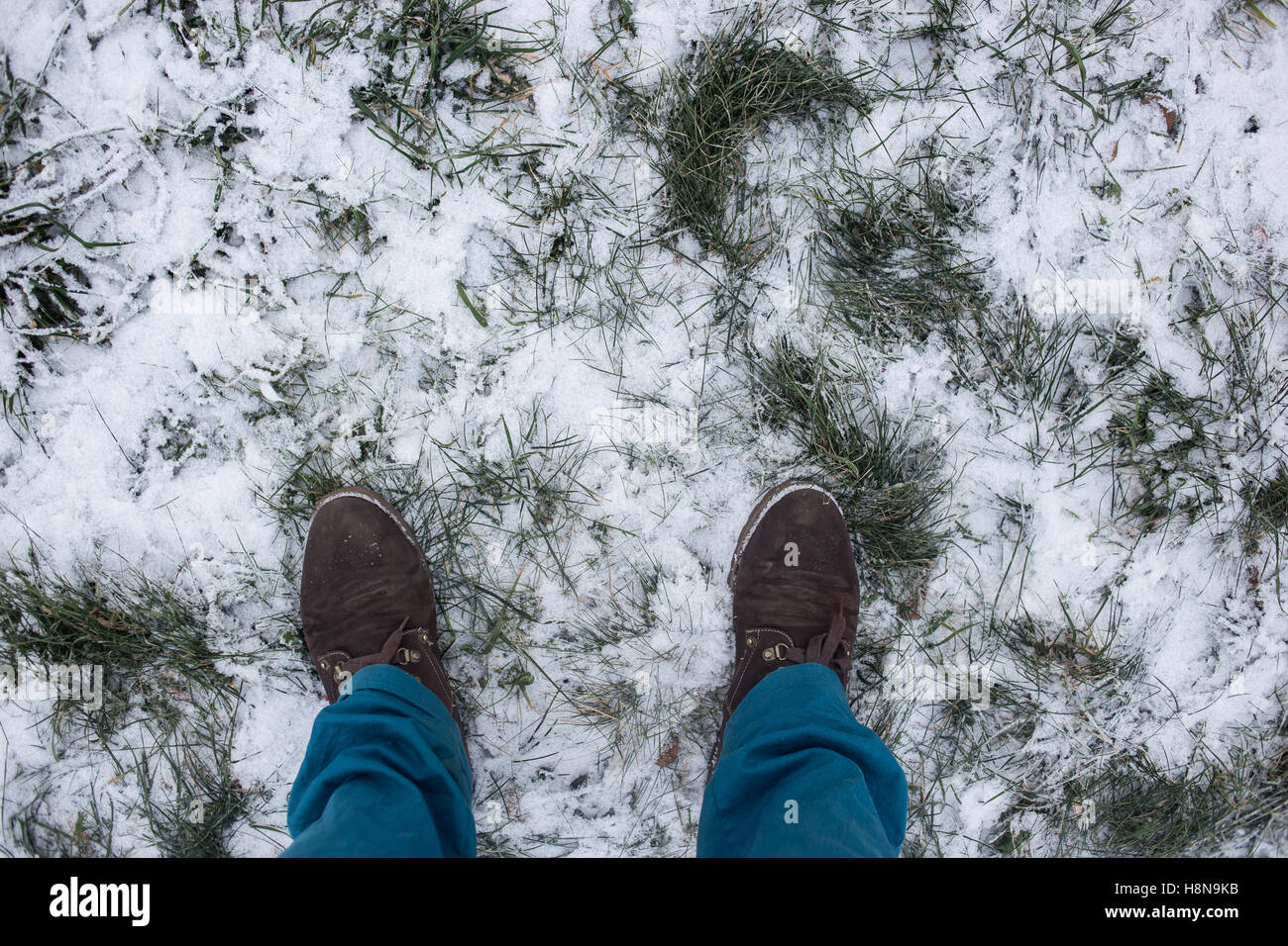 Male Boots In Winter Grass Under Snow Stock Photo - Alamy