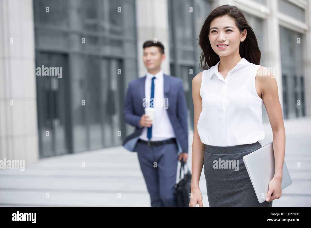 Confident Chinese businesswoman walking outdoors Stock Photo - Alamy