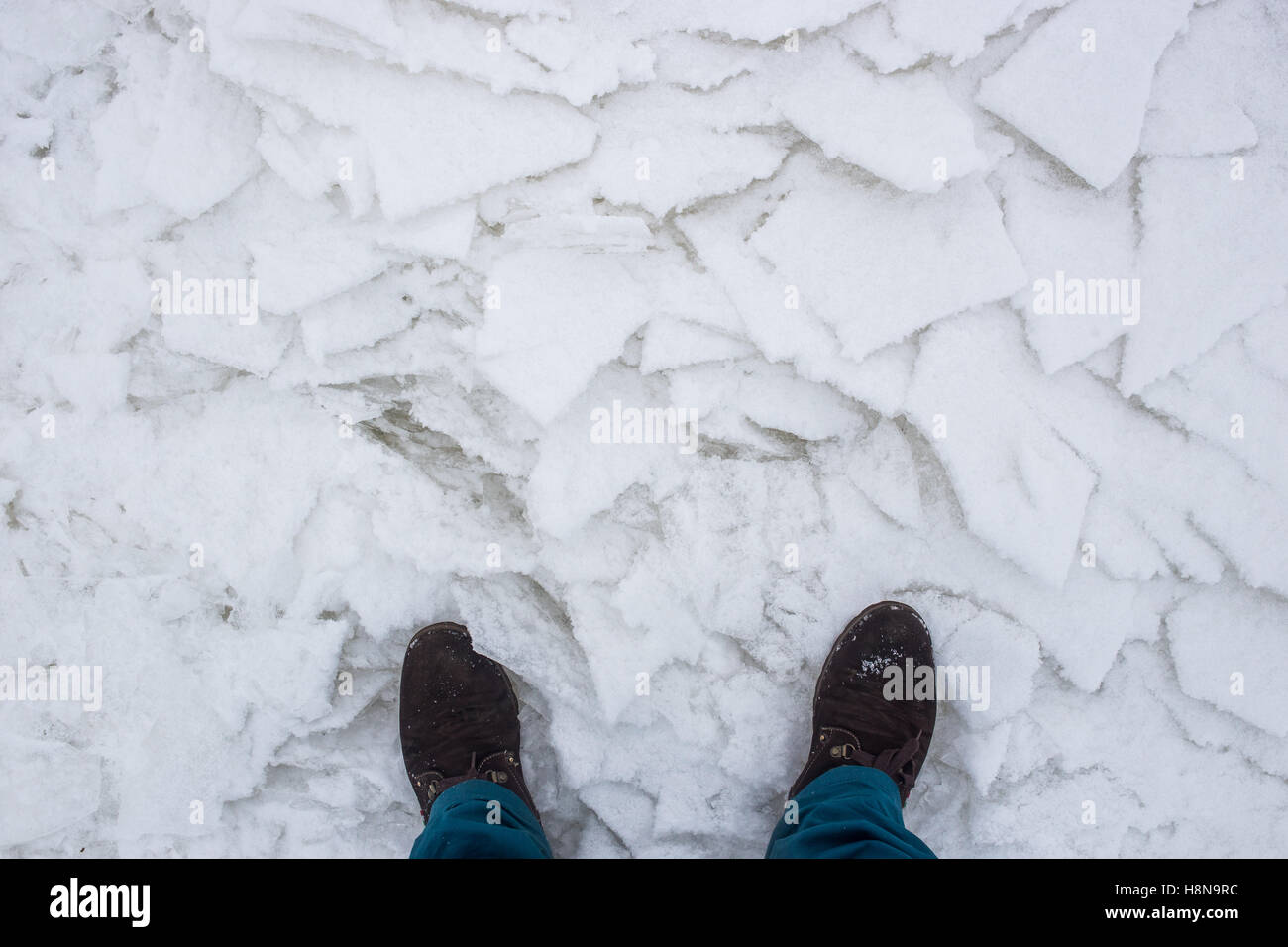 Hiking boots on river cracked snow, top view. Concept of danger an exit ...