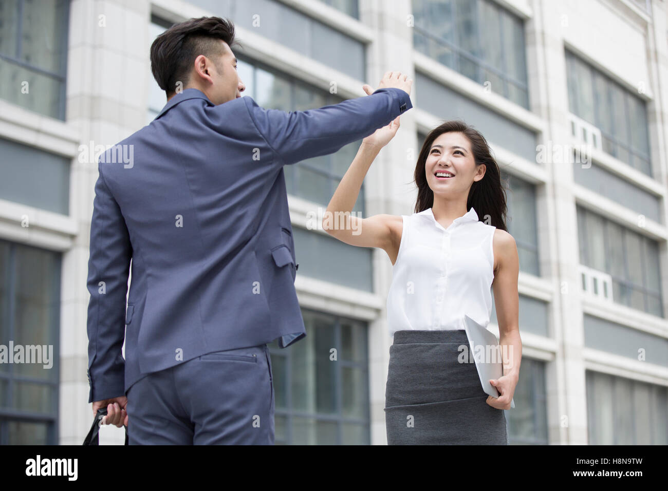 Confident Chinese business people high-fiving each other Stock Photo ...