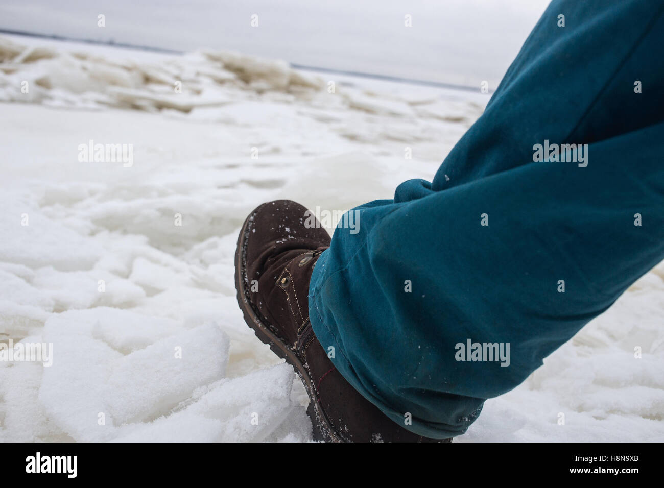 Male Feet On The Weak Bad River. Ice Concept danger falling through the ...