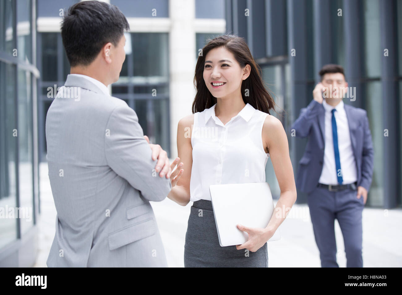 Confident Chinese business people talking outdoors Stock Photo - Alamy