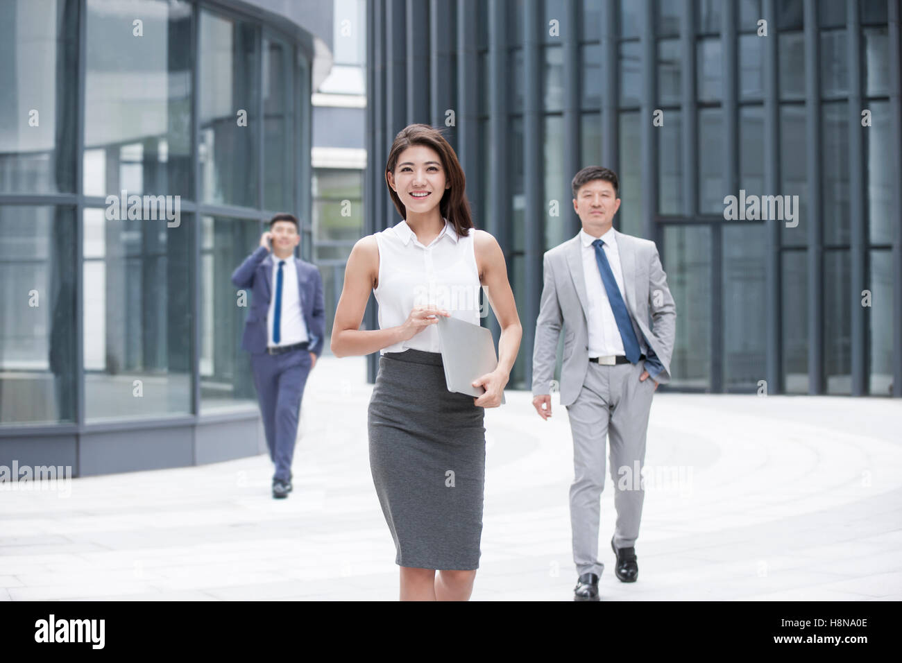 Confident Chinese business people walking outdoors Stock Photo - Alamy