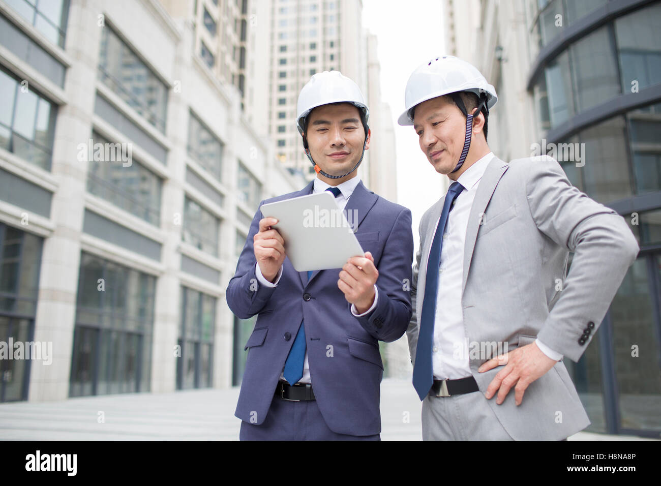 Chinese male architects talking with digital tablet outdoors Stock ...