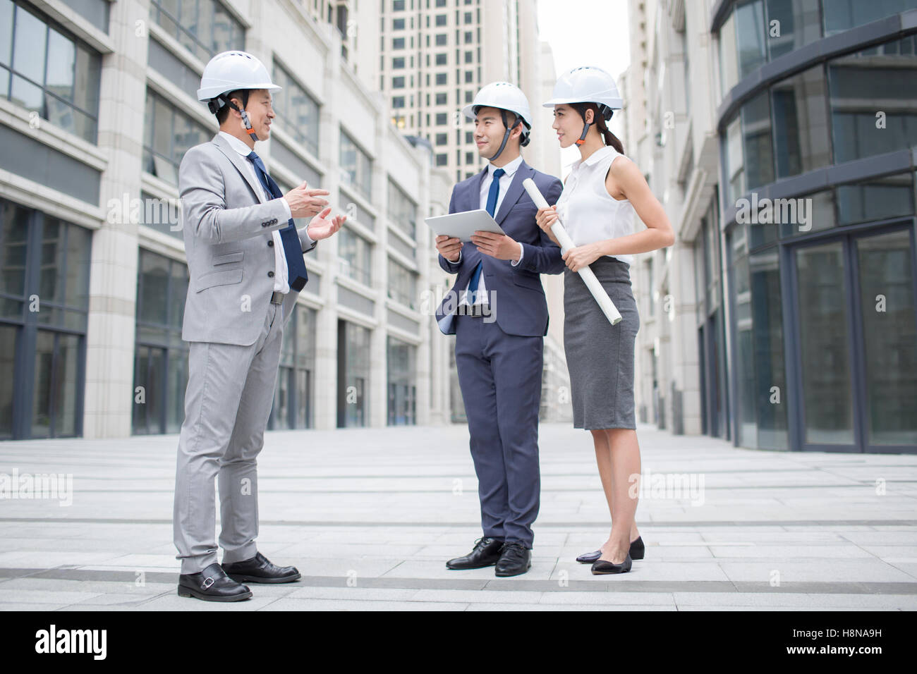 Confident Chinese architects talking outdoors Stock Photo - Alamy