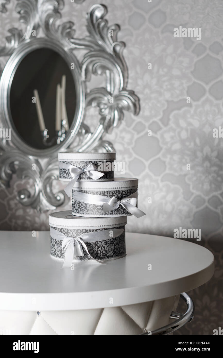 Three round celebration gift boxes with silver ribbon bows on white ...
