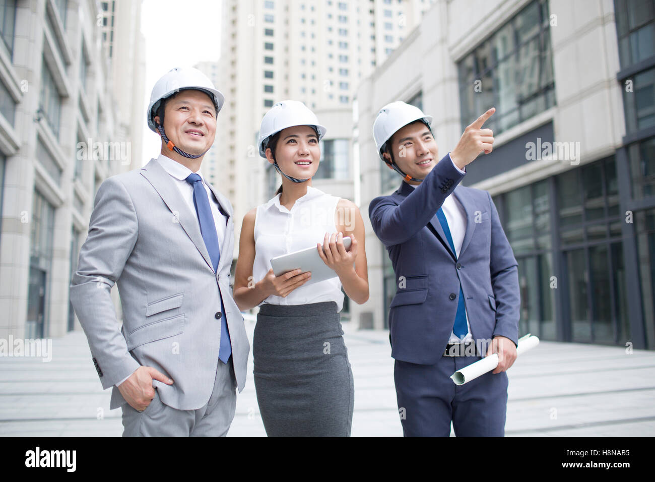 Confident Chinese architects talking outdoors Stock Photo - Alamy