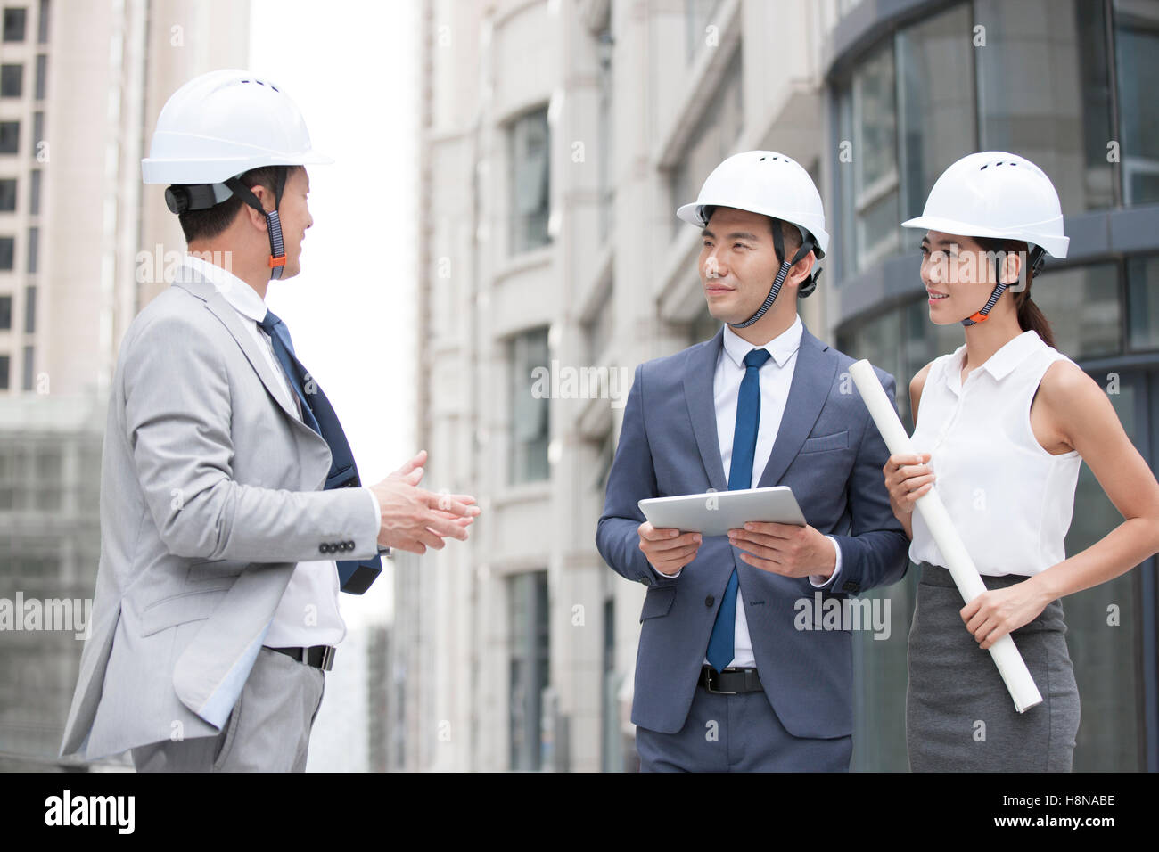 Confident Chinese architects talking outdoors Stock Photo - Alamy