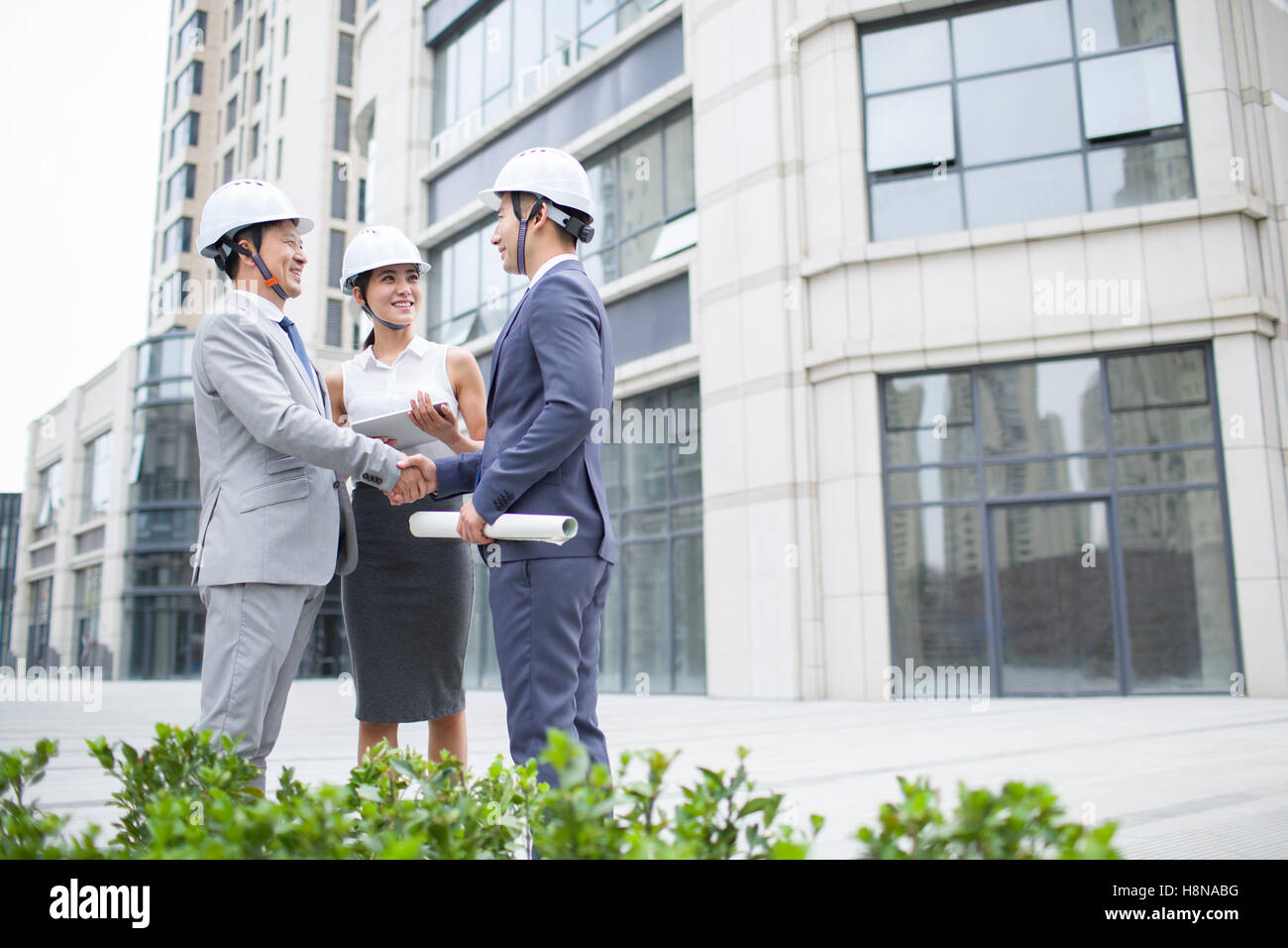 Confident Chinese architects talking outdoors Stock Photo - Alamy