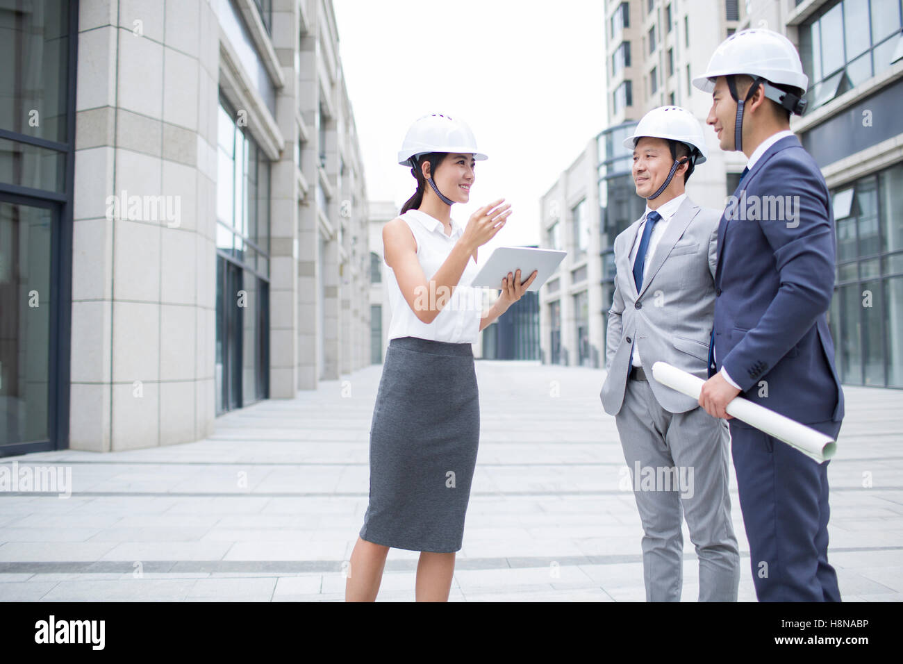 Confident Chinese architects talking outdoors Stock Photo - Alamy