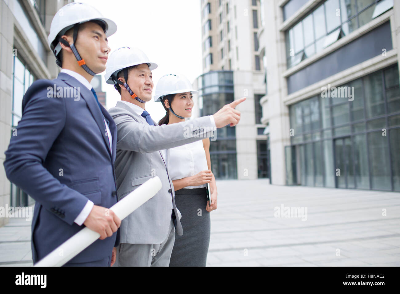 Confident Chinese architects talking outdoors Stock Photo - Alamy